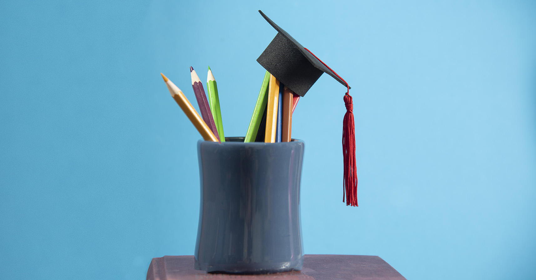 Education and back to school concept with graduation cap on pencils ...